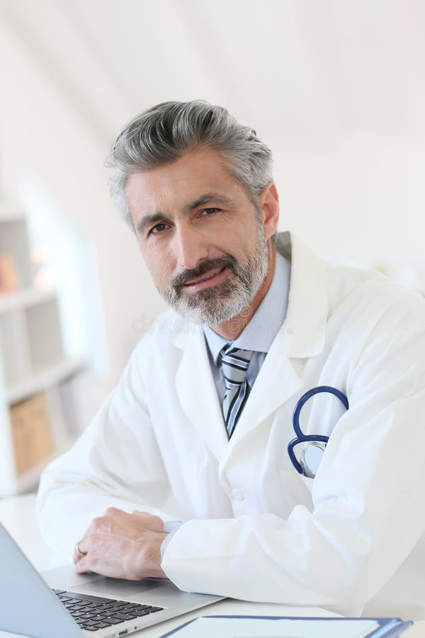 Doctor writing on laptop stock photo. Image of clinic - 51975832