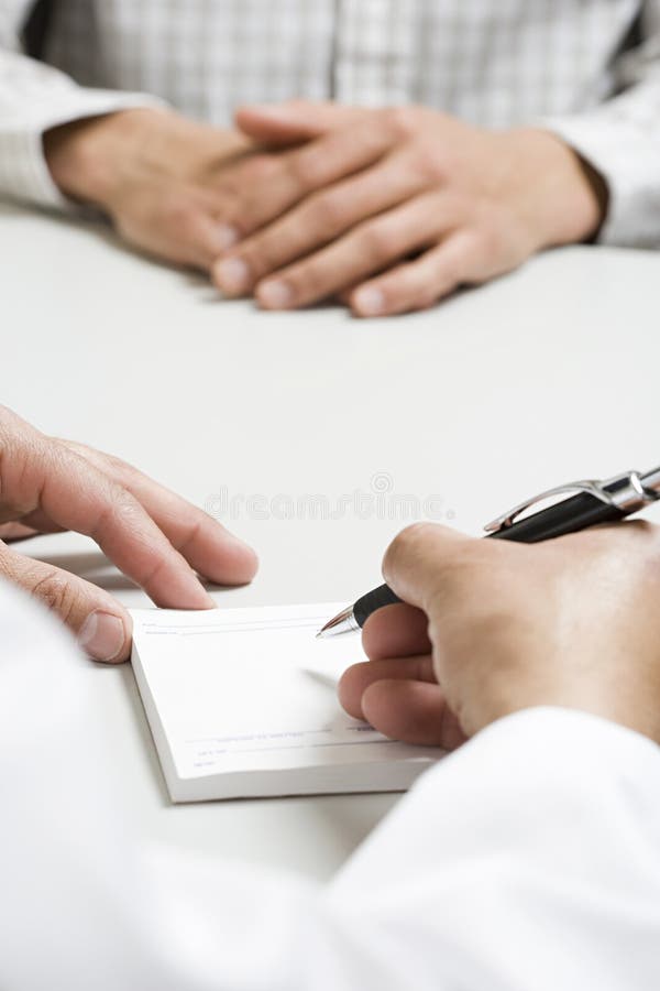 Doctor Writing on Medical Chart with a Smiling Patient Stock Image ...
