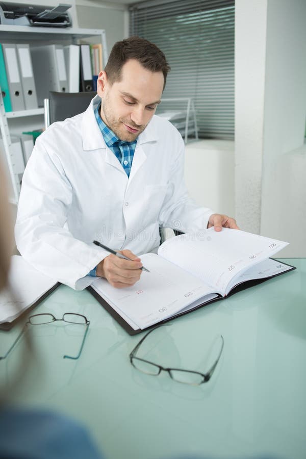 Doctor writing on schedule stock image. Image of care - 302960347