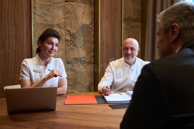 Doctors and Client are Sitting at a Desk and Talking Stock Image ...