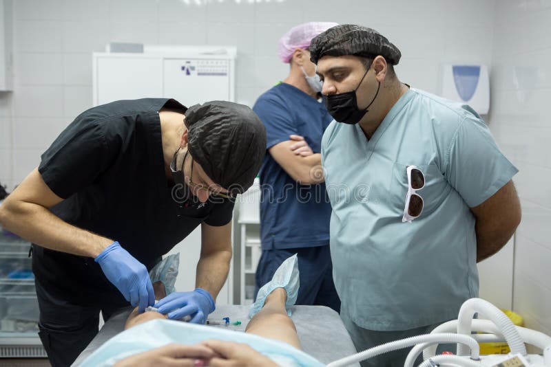Doctors Doing Vein Surgery Procedure Stock Photo - Image of clinic ...