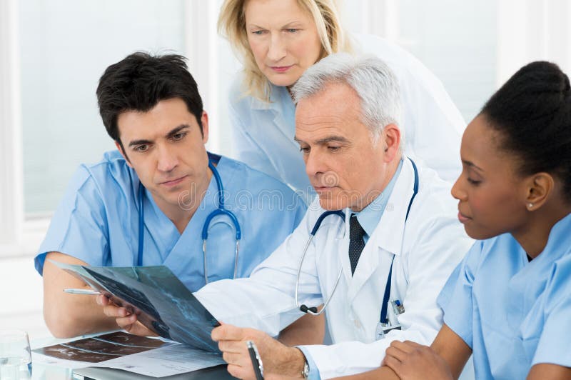 Team of Doctors Examining Reports Stock Photo - Image of discussing ...