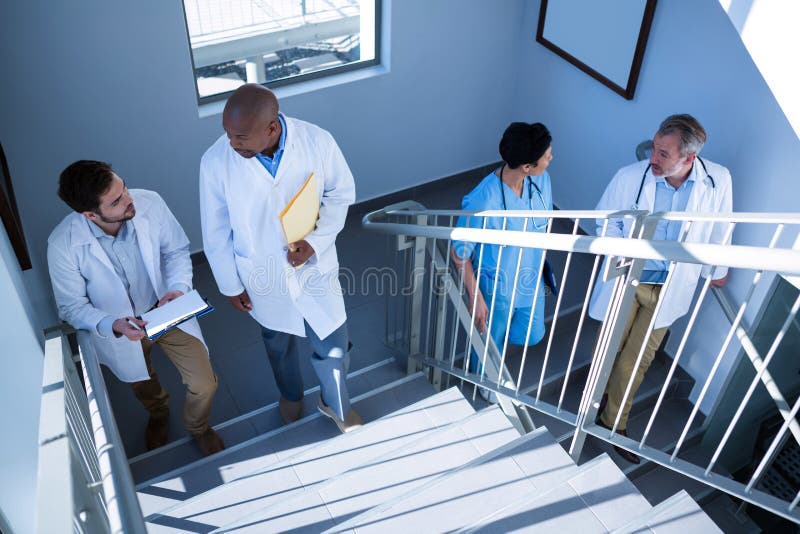 Doctors Interacting with Each Other while Climbing Stairs Stock Photo ...