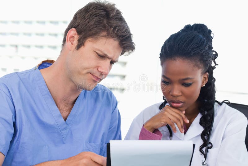 Doctors Looking at a Document Stock Photo - Image of holding, health ...