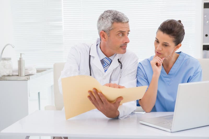 Doctors looking at files stock photo. Image of concentrate - 49886396