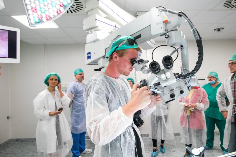 Doctors Looking into the Microscope in Surgery Room Editorial Image ...