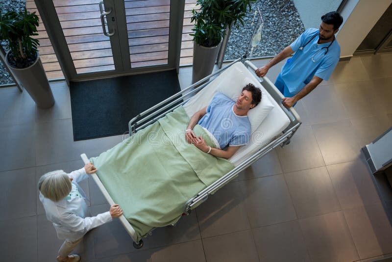 Doctors Pushing the Bed of a Patient Stock Photo - Image of staff ...