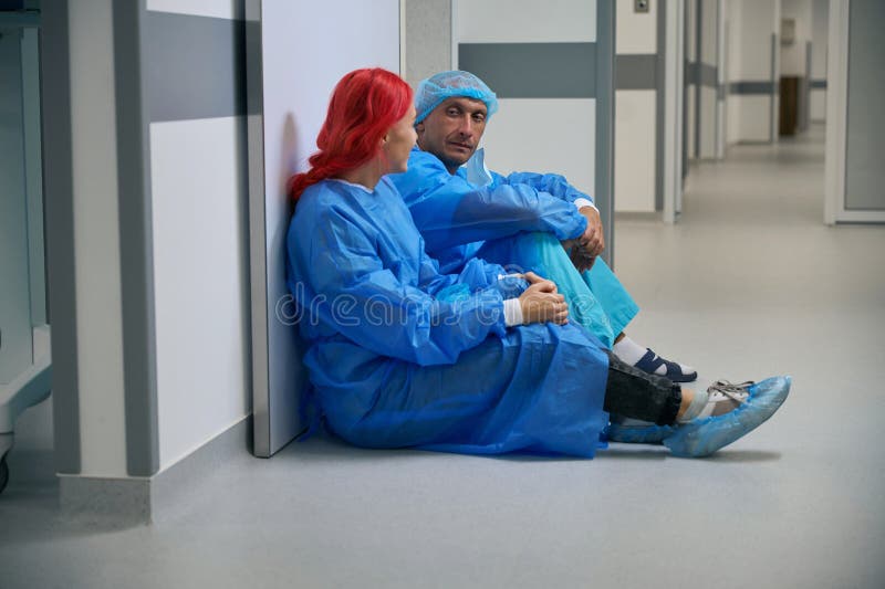 Doctors Sitting in Corridor Tired after Operation after Long Hours Work ...