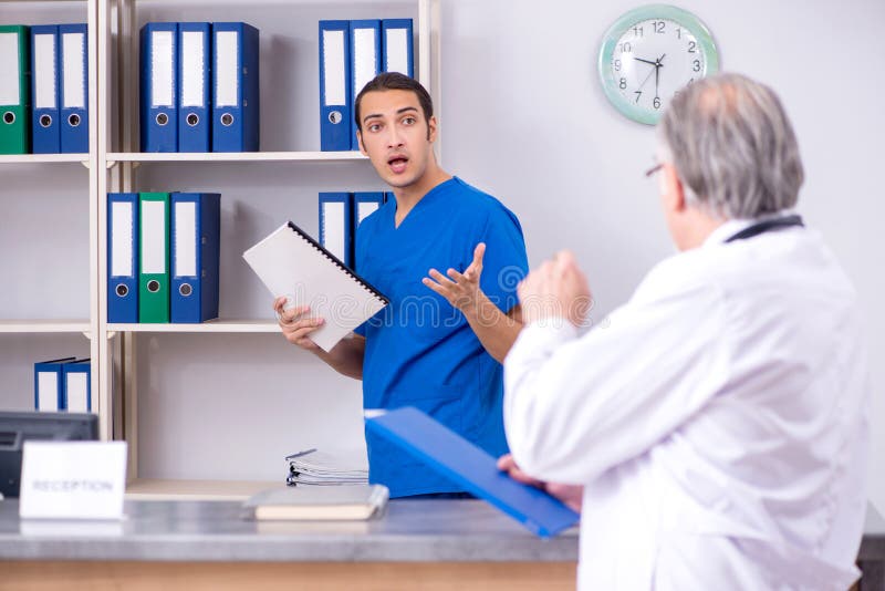Two Doctors Talking at the Reception in Hospital Stock Photo - Image of ...