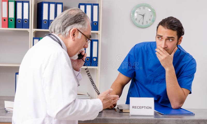 Two Doctors Talking at the Reception in Hospital Stock Image - Image of ...