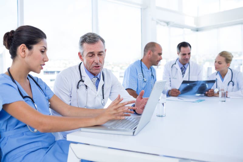 Doctors Using Computer Whiles Theirs Colleagues Looking at Xray Stock ...