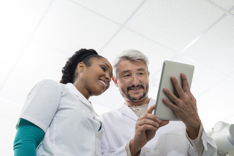 Doctors Using Digital Tablet in Examination Room Stock Photo - Image of ...