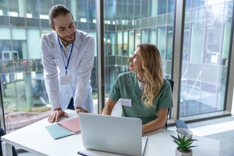 Doctors Working on PC Analyzing Research Data Talking with Colleagues ...