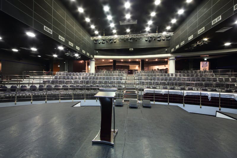 Document Stand on Stage and Rows of Chairs with Handrails in Large Hall ...