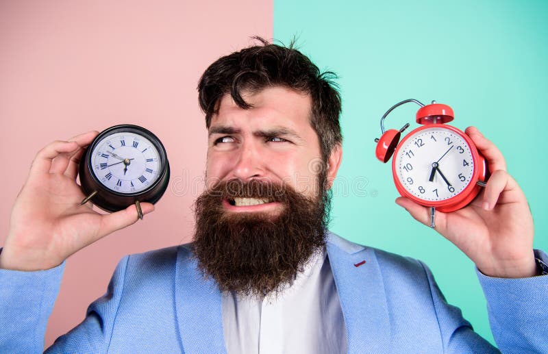 Does Changing Clock Mess with Your Health. Man Bearded Hipster Hold Two ...