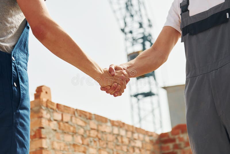 Doing Handshake. Two Construction Workers is Together at the Building ...