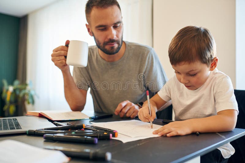 Doing Homework. Father and Son are at Home by the Table Stock Photo ...