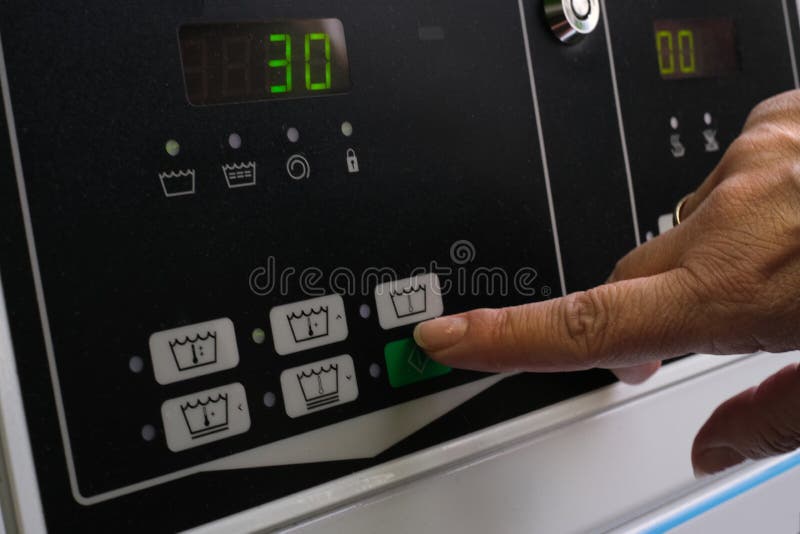 Doing the Laundry. the Man Presses the Start of the Washing Machine ...