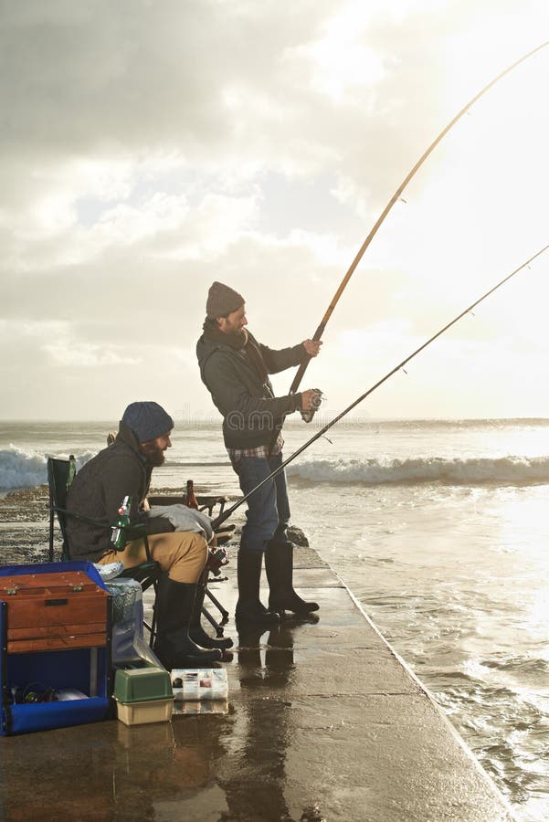Doing a Little Fishing. Two Young Men Fishing Off a Pier. Stock Image ...