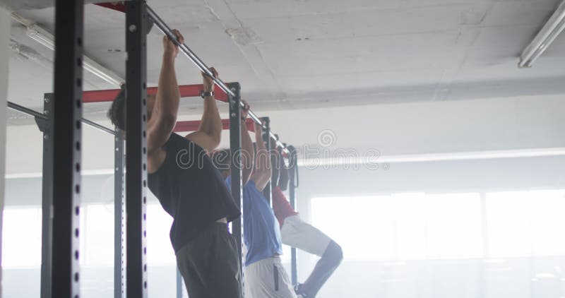Doing Pull-ups, Men Exercising on Pull-up Bars in Gym, Building ...