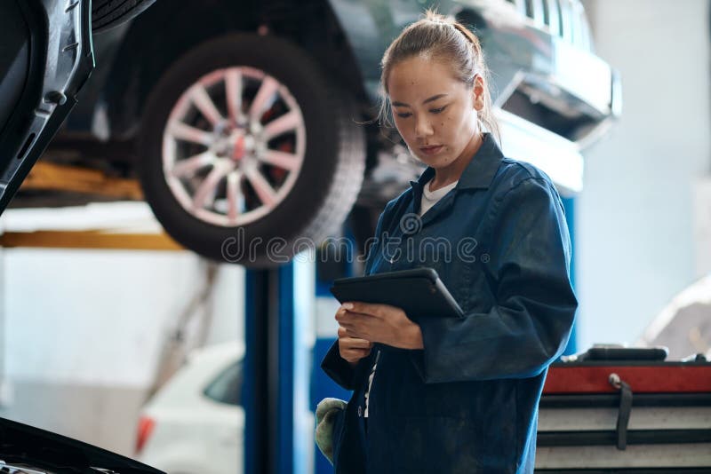 Doing a Quick System Check. a Female Mechanic Holding a Digital Tablet ...