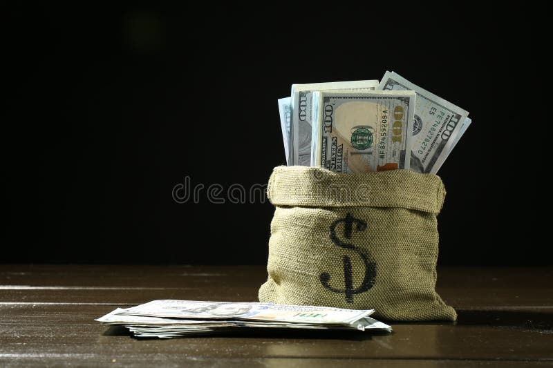 Dollar Banknotes in Sack on Wooden Table Against Dark Background Stock ...