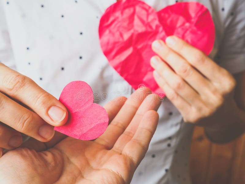 Donated Heart. Large and Small Red Heart in His Hand. Stock Image ...