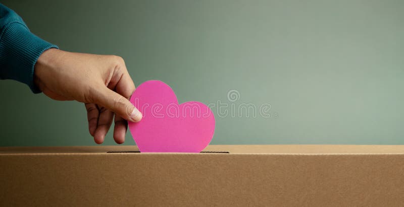 Donation Concept. Hand Dropping a Pink Paper Heart into a Donate Box ...