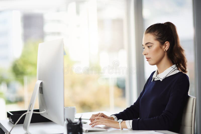 Almost Done with this Assignment. an Attractive Young Businesswoman Sitting at Her Desk and ...