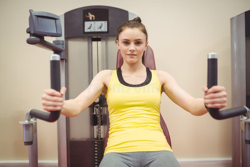 Donna Adatta Che Per Mezzo Della Macchina Dei Pesi Immagine Stock ...