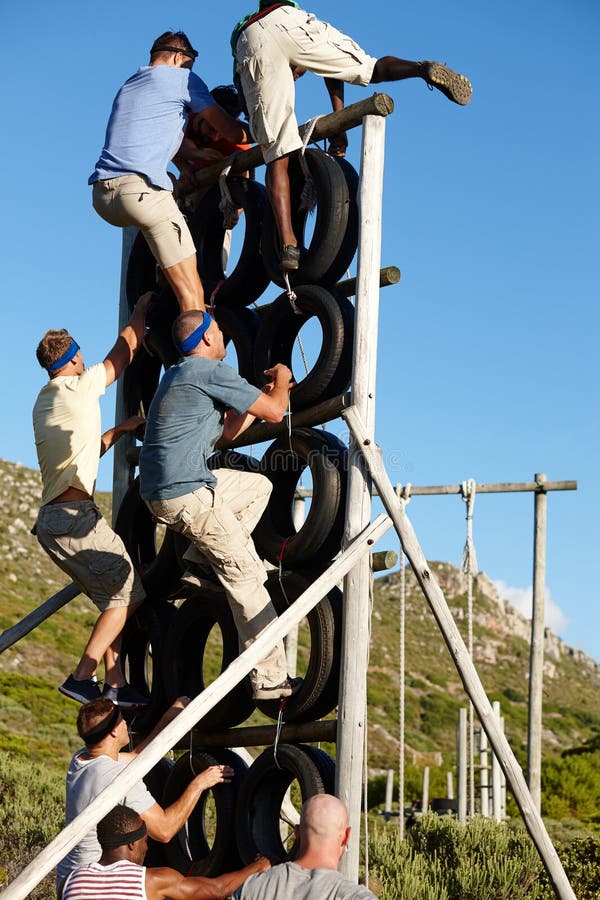 Dont Let Obstacles Stop You. a Group of Men Climbing Over an Obstacle ...