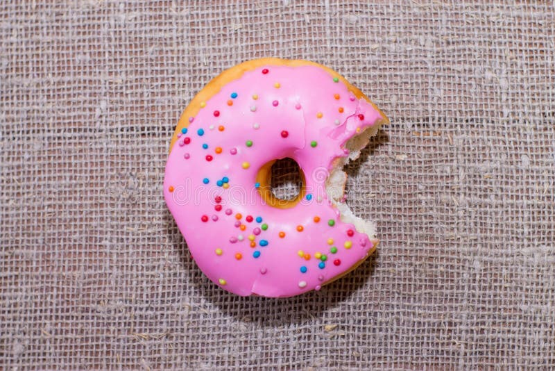Donut with Pink Icing on the Table. Snacks Bitten Donut Stock Photo ...