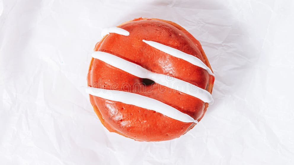 Donut with Red Icing and White Lines on White Paper Stock Photo - Image ...