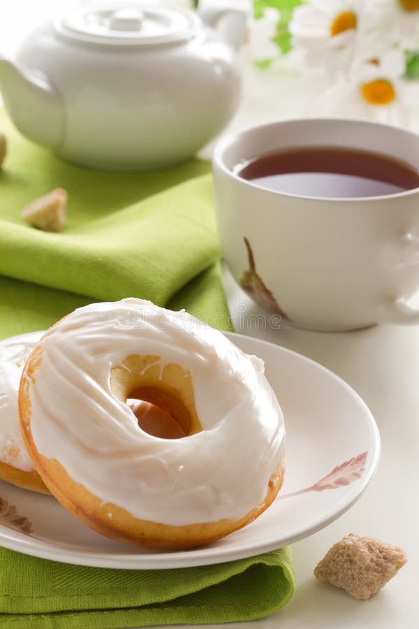 Donuts With Chocolate Icing, A Cup Of Tea, Close-up Stock Photo - Image ...