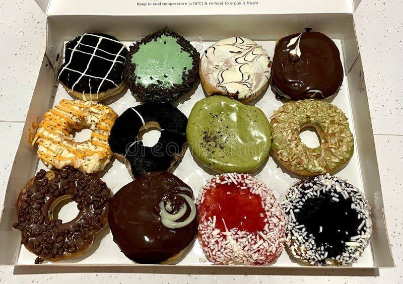 12 Donuts of Various Flavors and Colors in a Box Packaging Stock Image ...