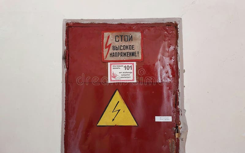Door with the Sign "Stop. High Voltage", "in Case of Fire Call 101 ...