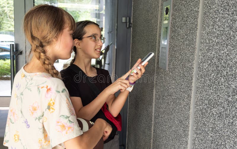 Dos Adolescentes Accediendo Al Edificio Conectando Un Smartphone a ...