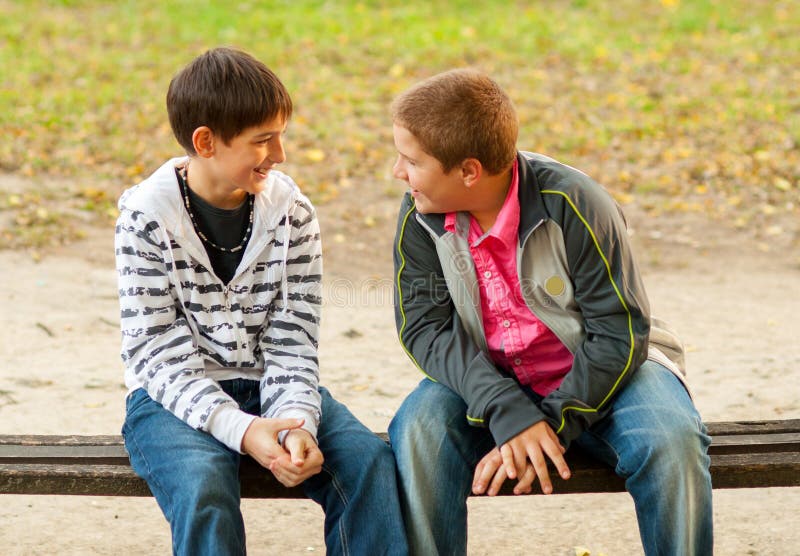 Dos Amigos Adolescentes Que Hablan En El Parque Foto de archivo ...