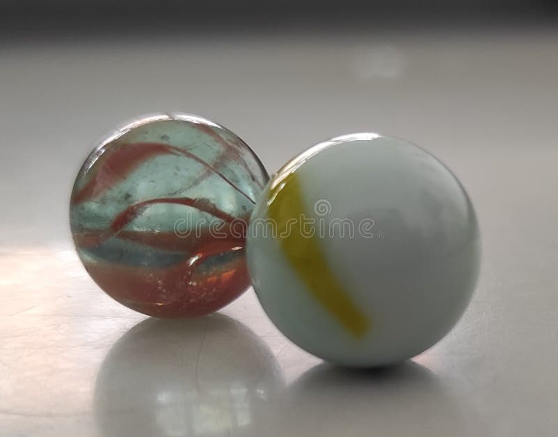 Dos canicas en el suelo foto de archivo. Imagen de gemela - 262051146