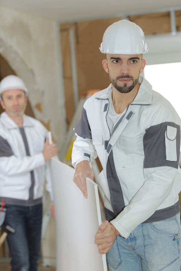 Dos Constructores Varones Que Llevan El Embarque Imagen de archivo - Imagen de pasos, tablero ...