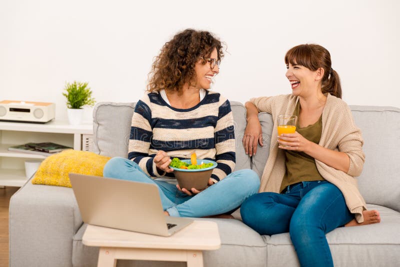 Amigos Femeninos En Casa Que Se Sientan Alrededor De La Tabla Para El ...