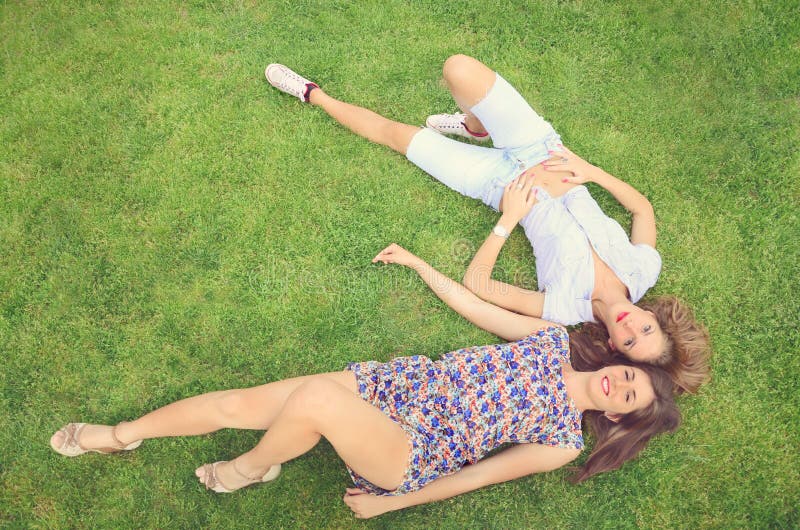 Dos Morenitas Hermosas Que Mienten En La Hierba Imagen de archivo ...