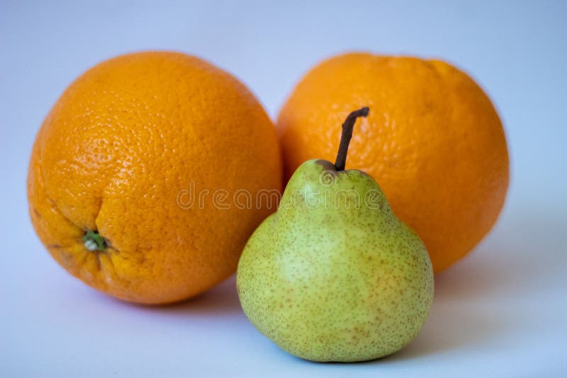Dos Naranjas Y Una Pera Sobre Un Fondo Blanco Aislado Imagen de archivo ...