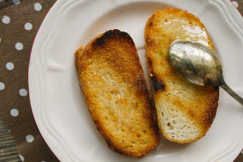 Dos Pedazos De Pan Asado En El Plato Blanco Foto de archivo - Imagen de ...
