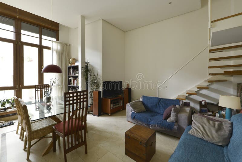 Double-height Loft with Dining Table, Several Sofas, Wooden Furniture ...