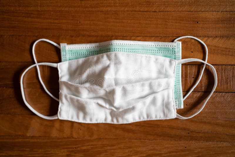 Double Masking. Cloth Mask and Surgical Mask on Wooden Table. Stock ...