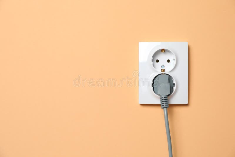 Double Power Socket with Inserted Plug on Pale Orange Wall, Space for ...