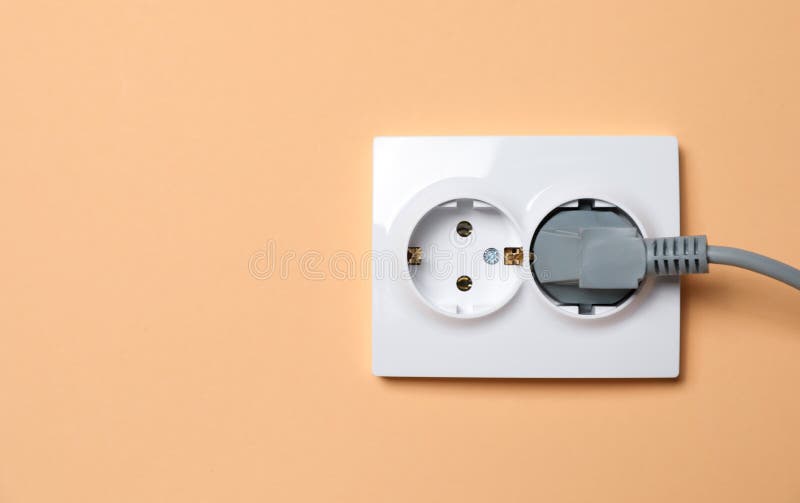 Double Power Socket with Inserted Plug on Pale Orange Wall, Space for ...
