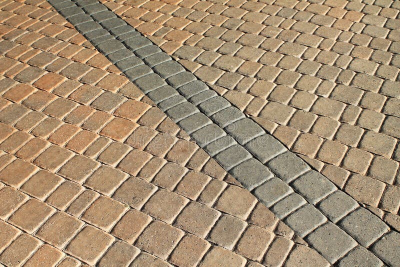Double Row of Gray Pavers Cuts through Solid Grid of Brown Stone Bricks ...