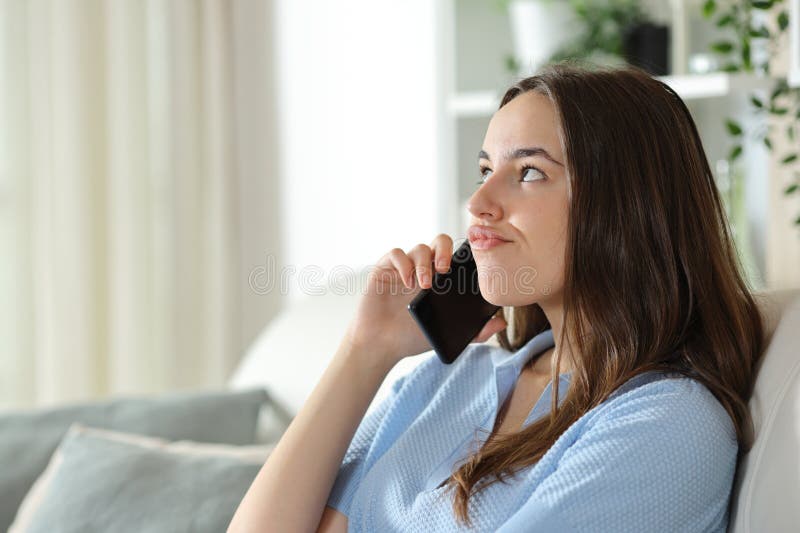 Doubtful Woman Talking on Phone at Home Stock Photo - Image of ...
